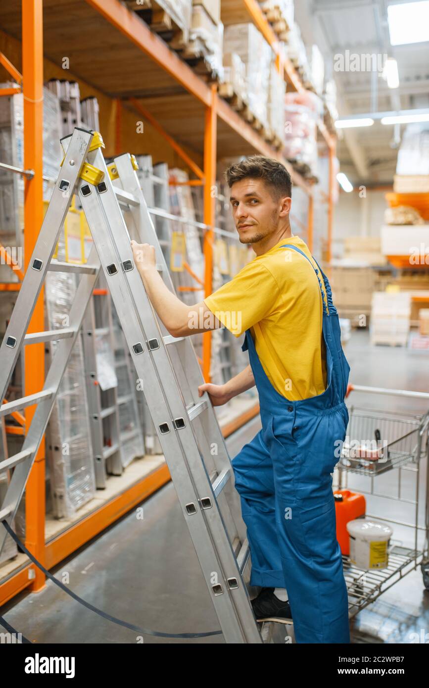 Male constructor climbing the stairs in hardware store. Builder in ...