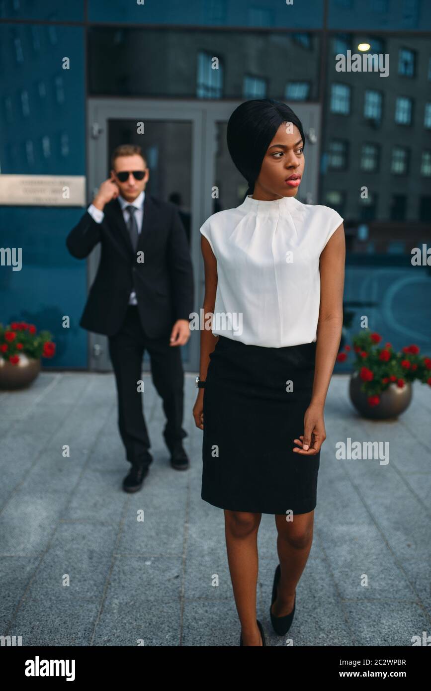 Black business woman bodyguard in suit and sunglasses on background ...