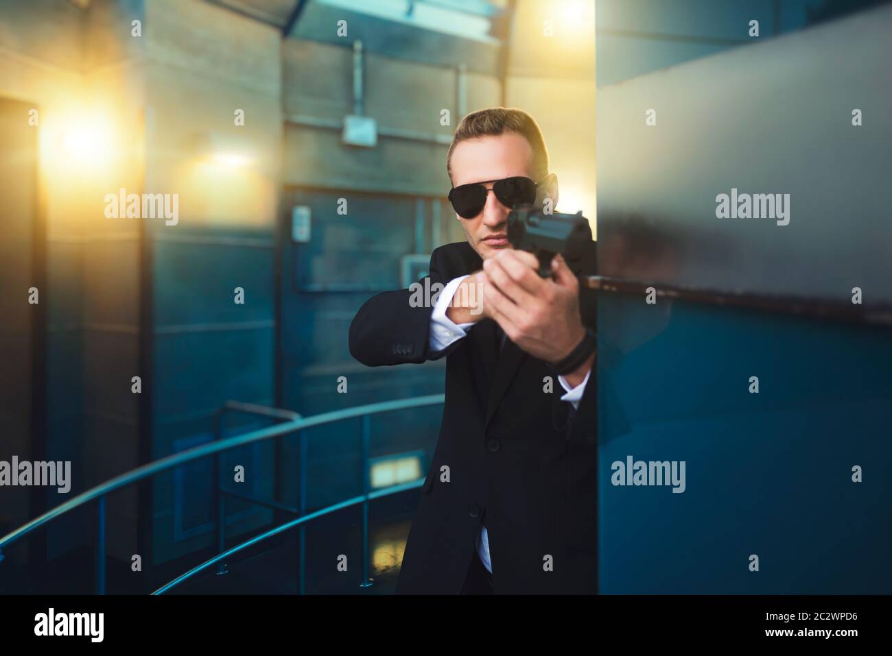 Bodyguard in suit and sunglasses with a gun in his hands. Security ...