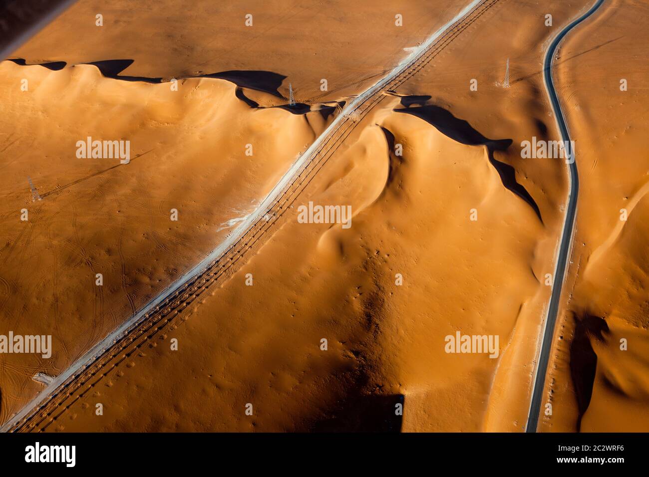 A road, oil export pipelines and electricity plyons in the Sahara ...