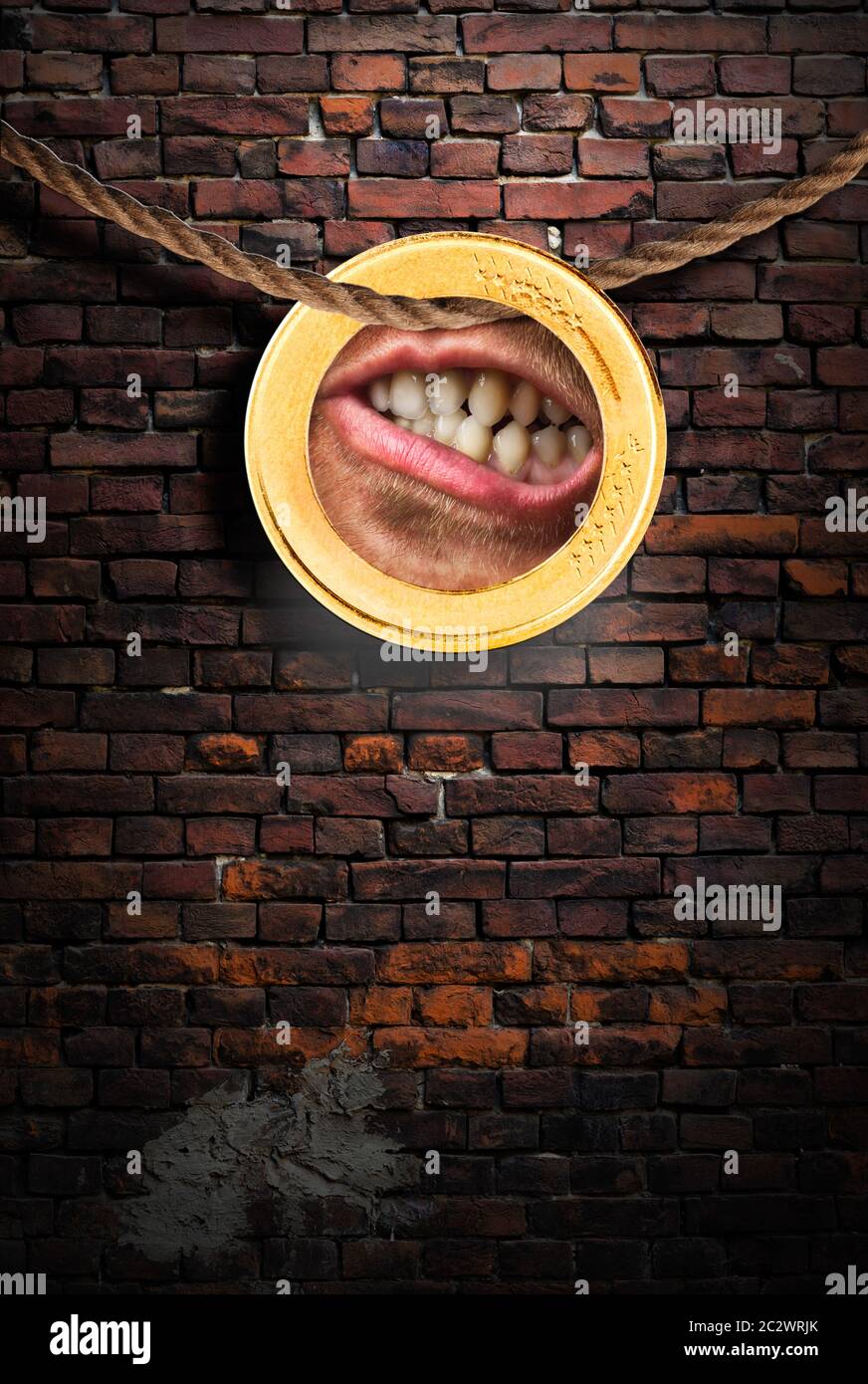 Human mouth in the coin hanging on the rope against a brick wall Stock ...