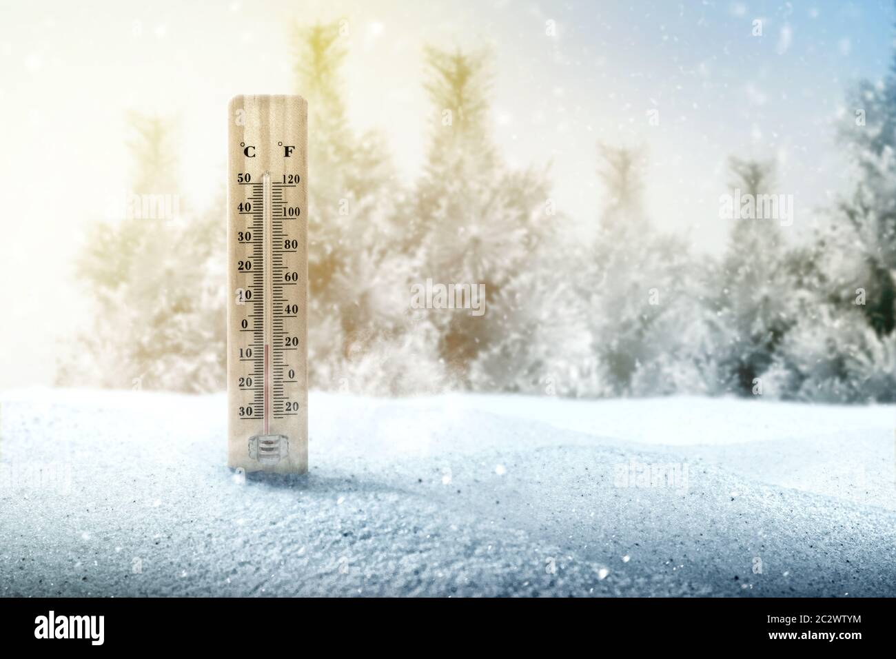 Wooden thermometer with the low temperature at winter with snowfall ...