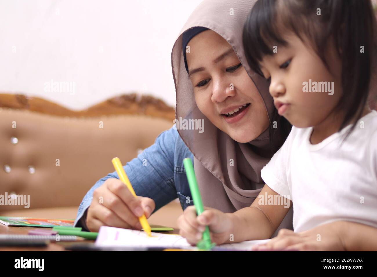 Asian muslim mother drawing with her daughter, single mom teaching baby ...
