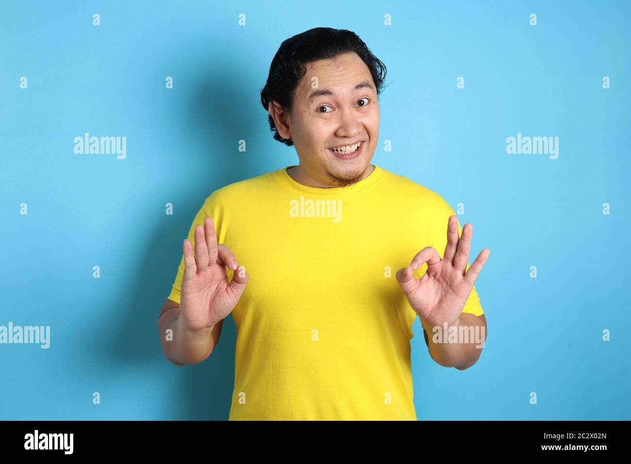 Young Asian man shows okay OK sign. Close up body portrait against ...