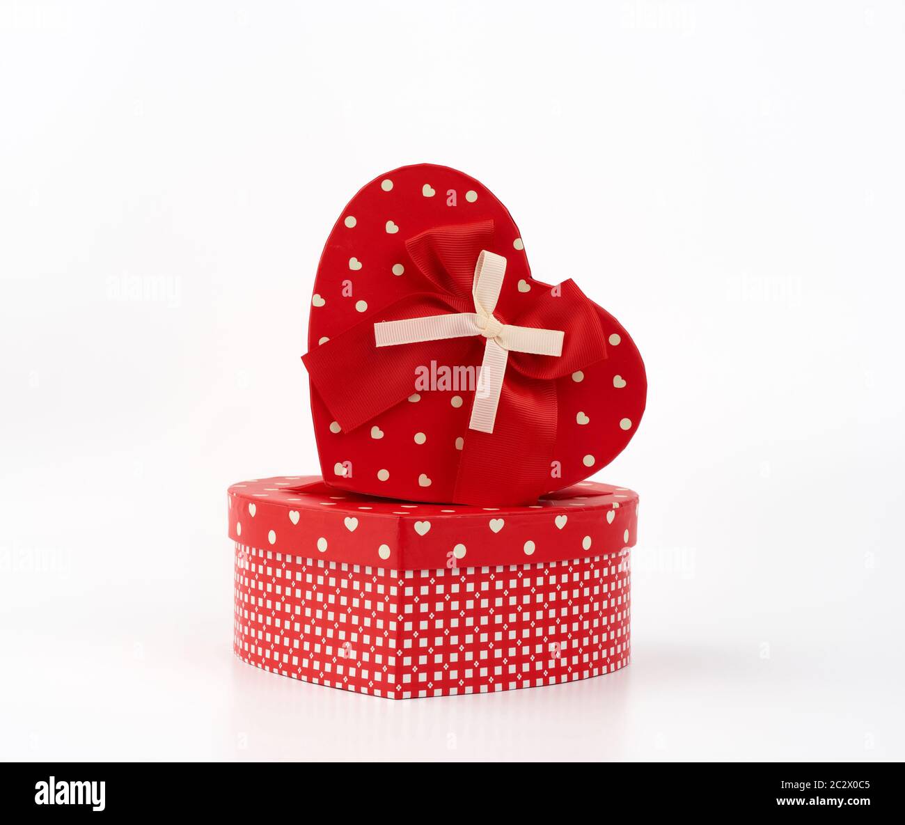 red heart-shaped cardboard box with bow on white background, holiday ...