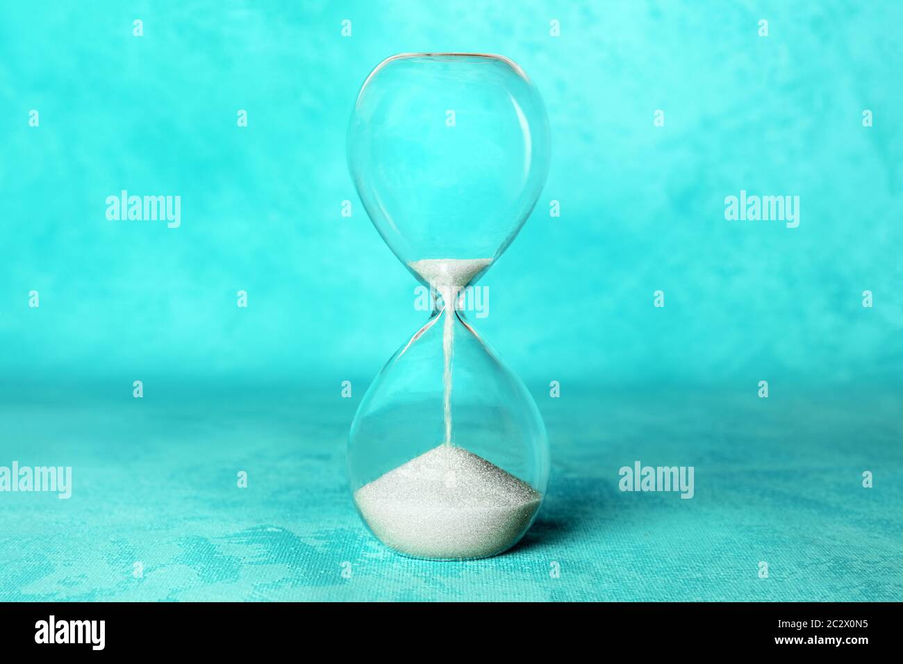 Time is running out concept. An hourglass with sand falling through, on ...