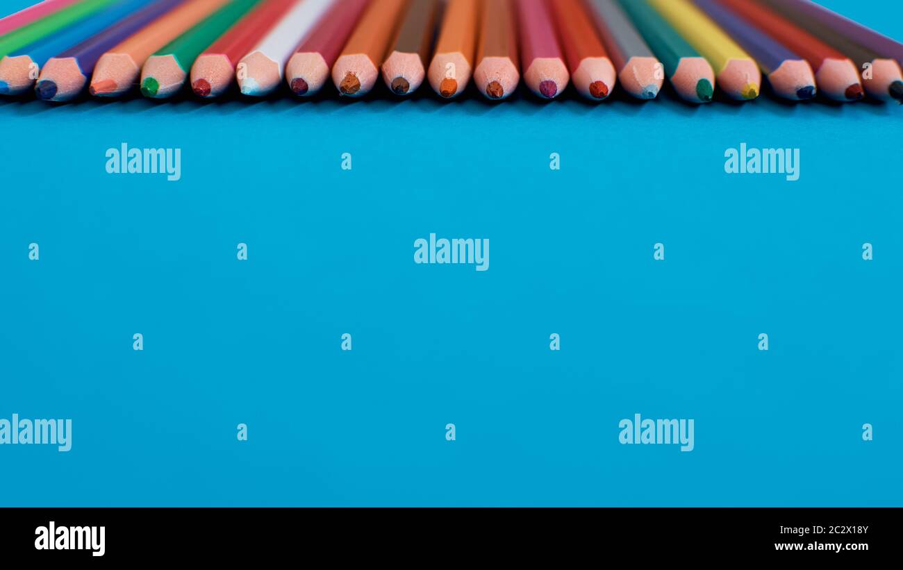 Color pencils in a row on a blue background. Copy space Stock Photo - Alamy