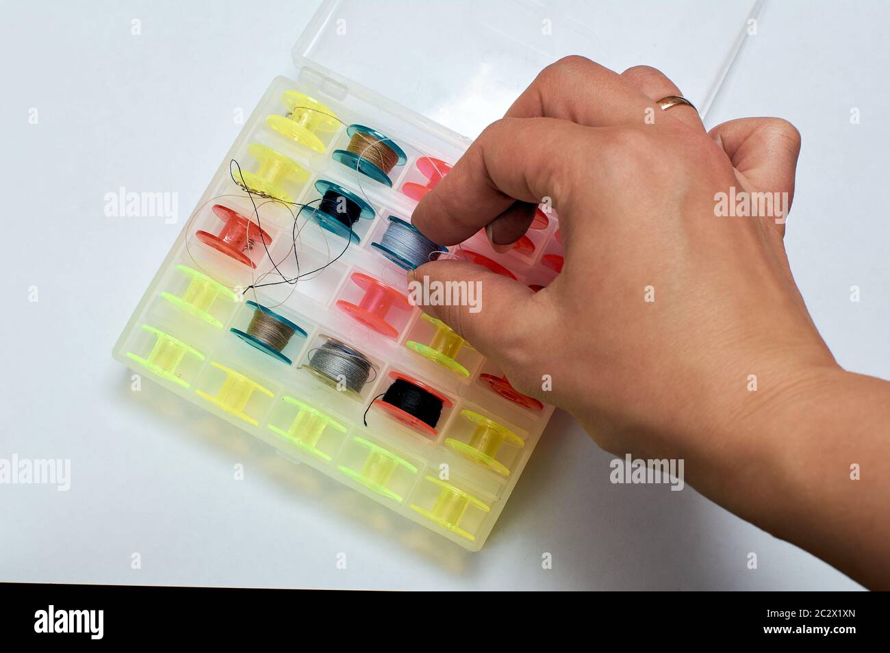 spools of thread in a box. Garbage craft. Woman's hand pulls the thread ...