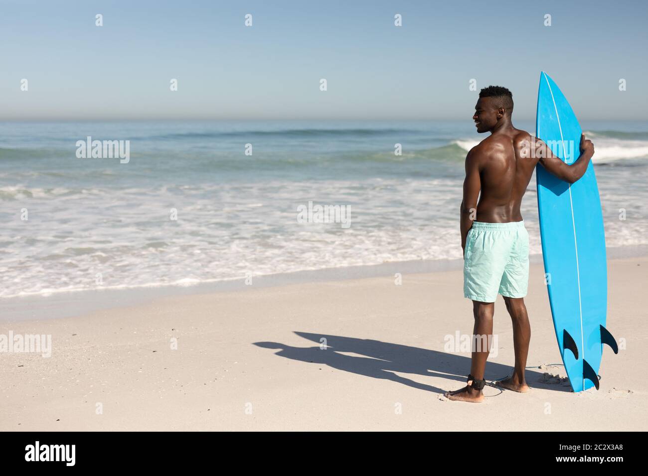 African American man holding surf board on the beach Stock Photo - Alamy