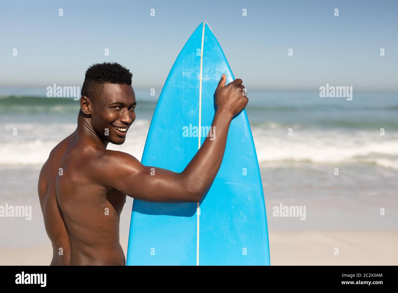 African American man holding surf board on the beach Stock Photo - Alamy