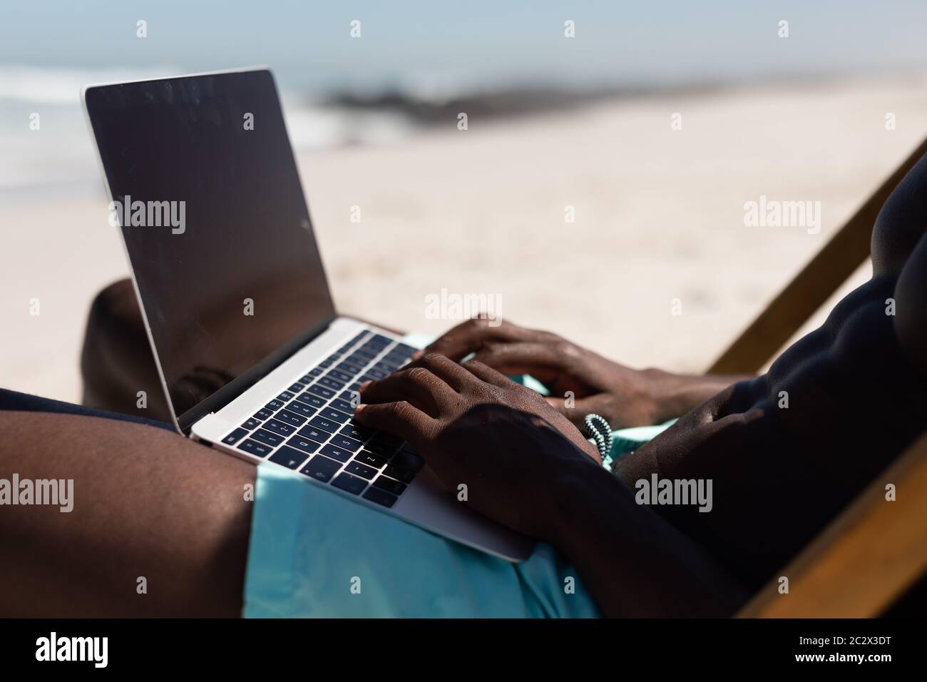 African American man using computer on the beach Stock Photo - Alamy