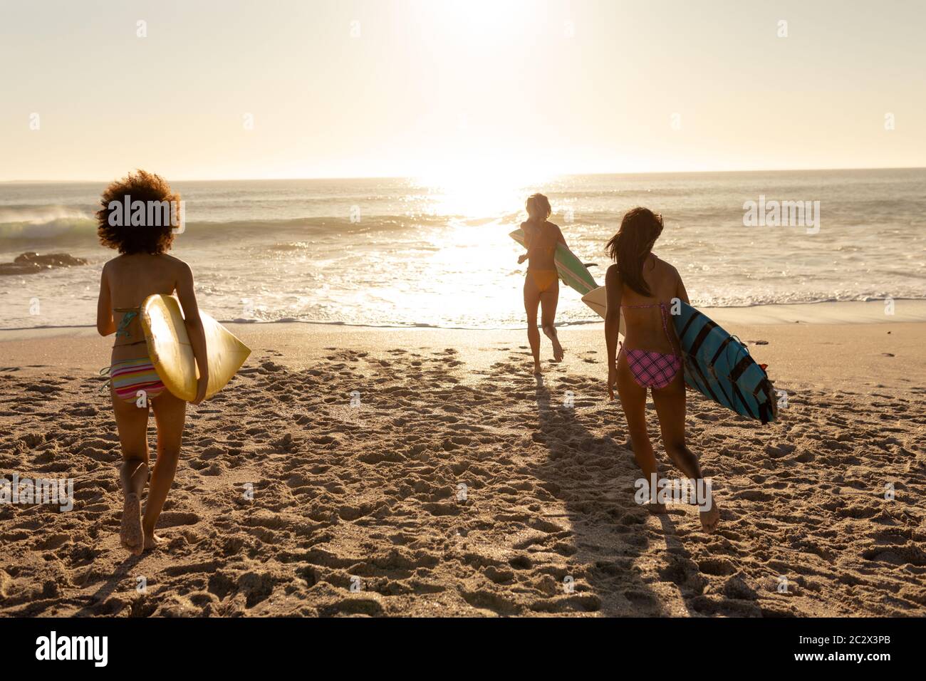 Young mixed race people holding surf boards on beach Stock Photo - Alamy