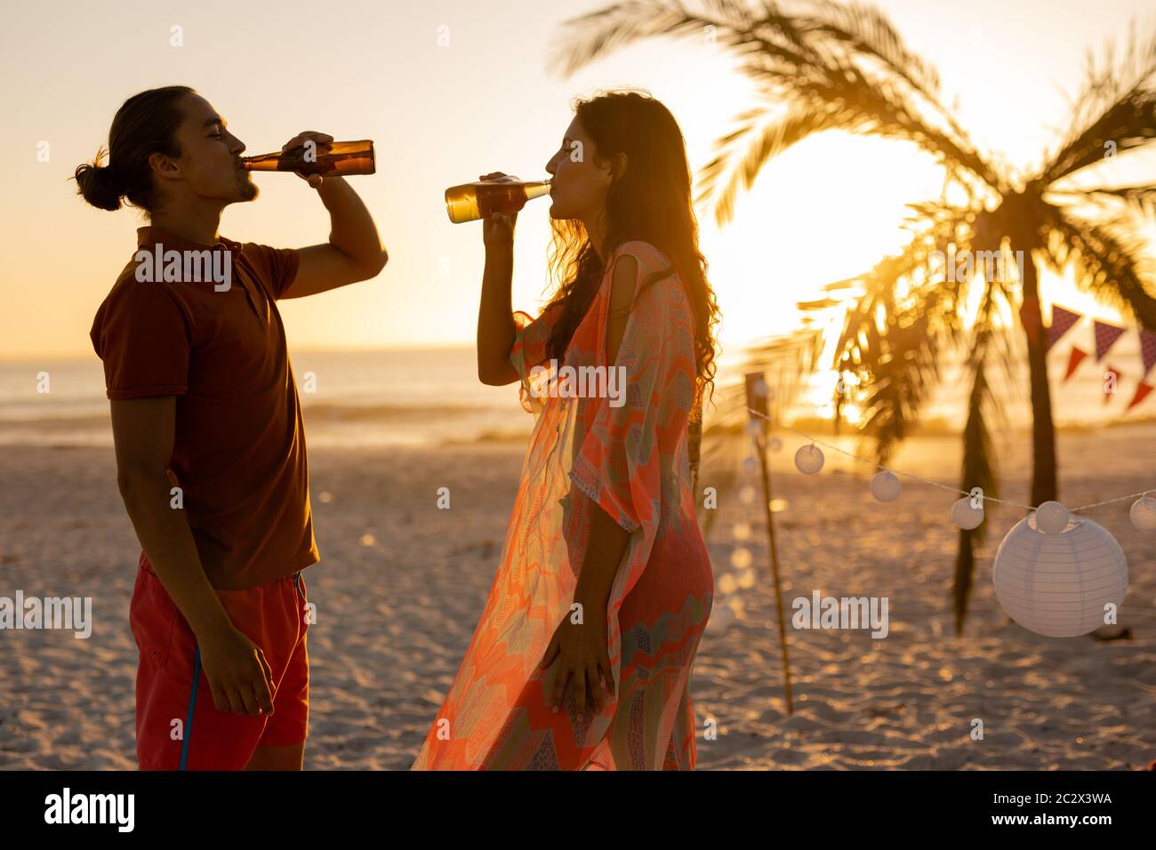 Caucasian couple drinking alcohol on beach Stock Photo - Alamy