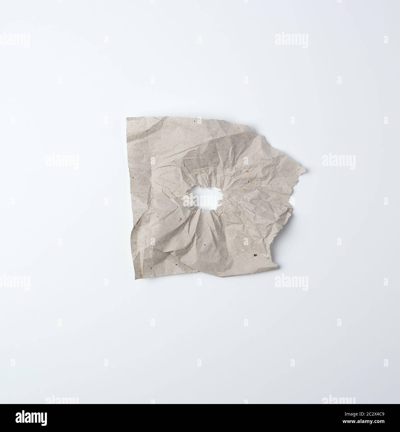 gray crumpled sheet of paper with a hole, white backing, abstract ...