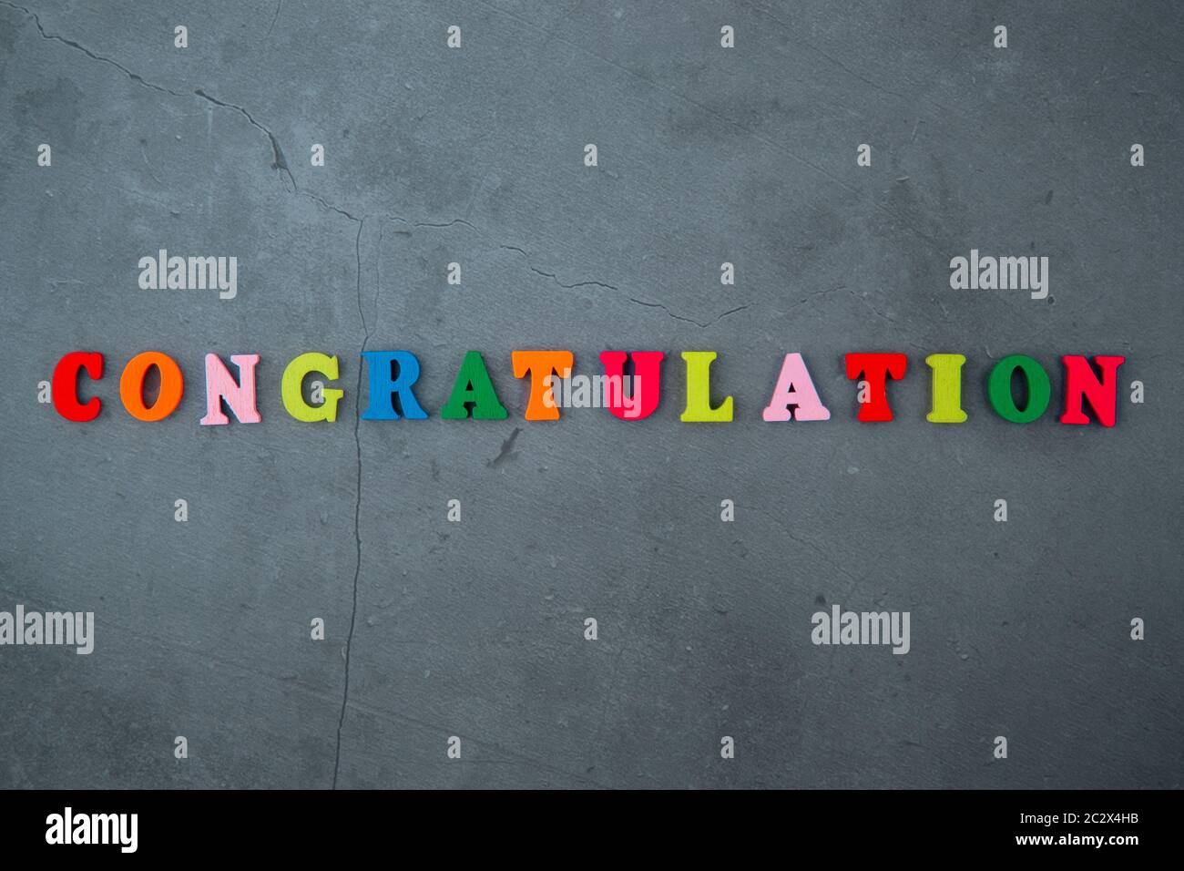 The multicolored congratulation word is made of wooden letters on a ...