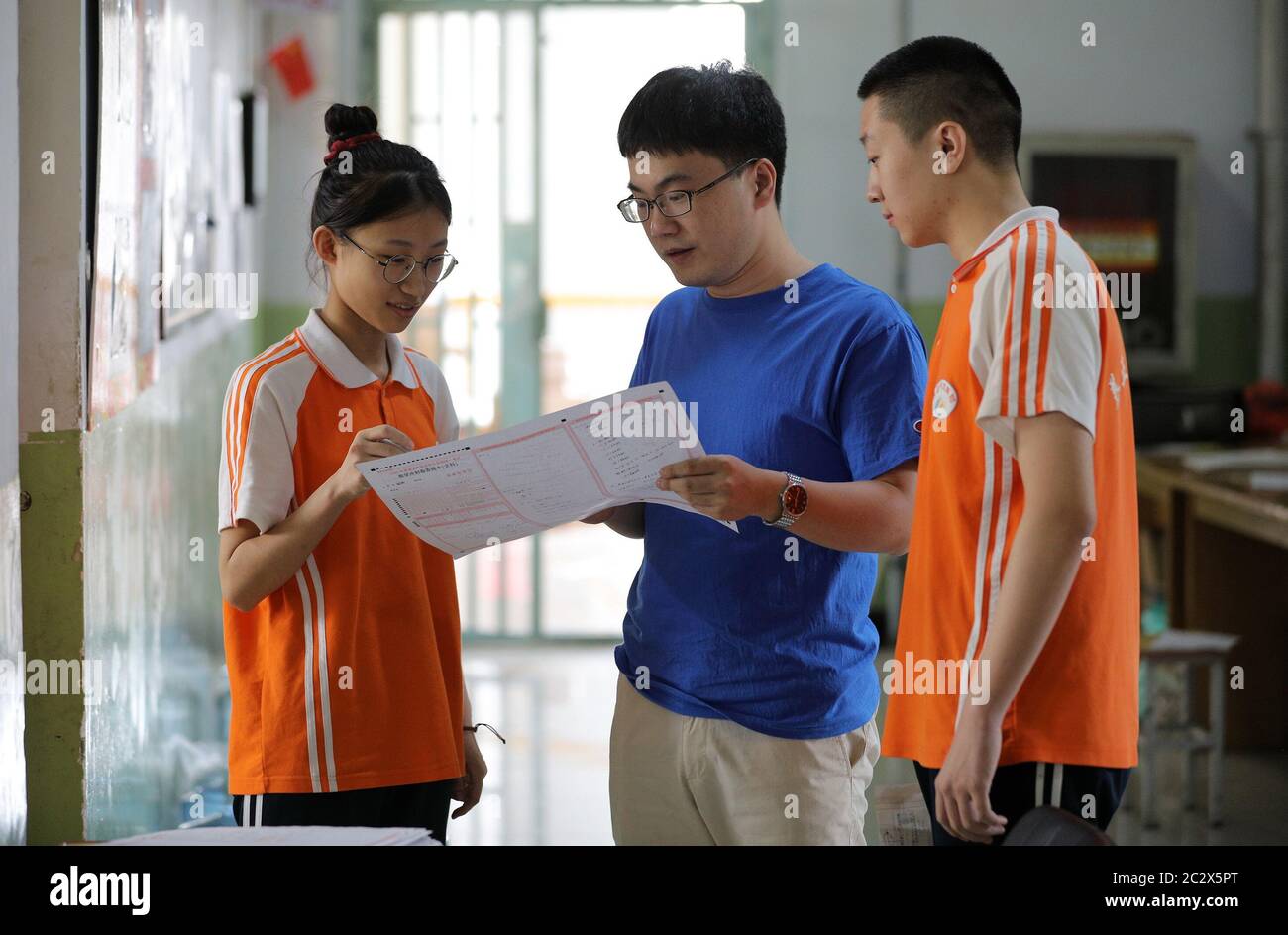 Hengshui, China's Hebei Province. 18th June, 2020. A teacher (C) helps ...