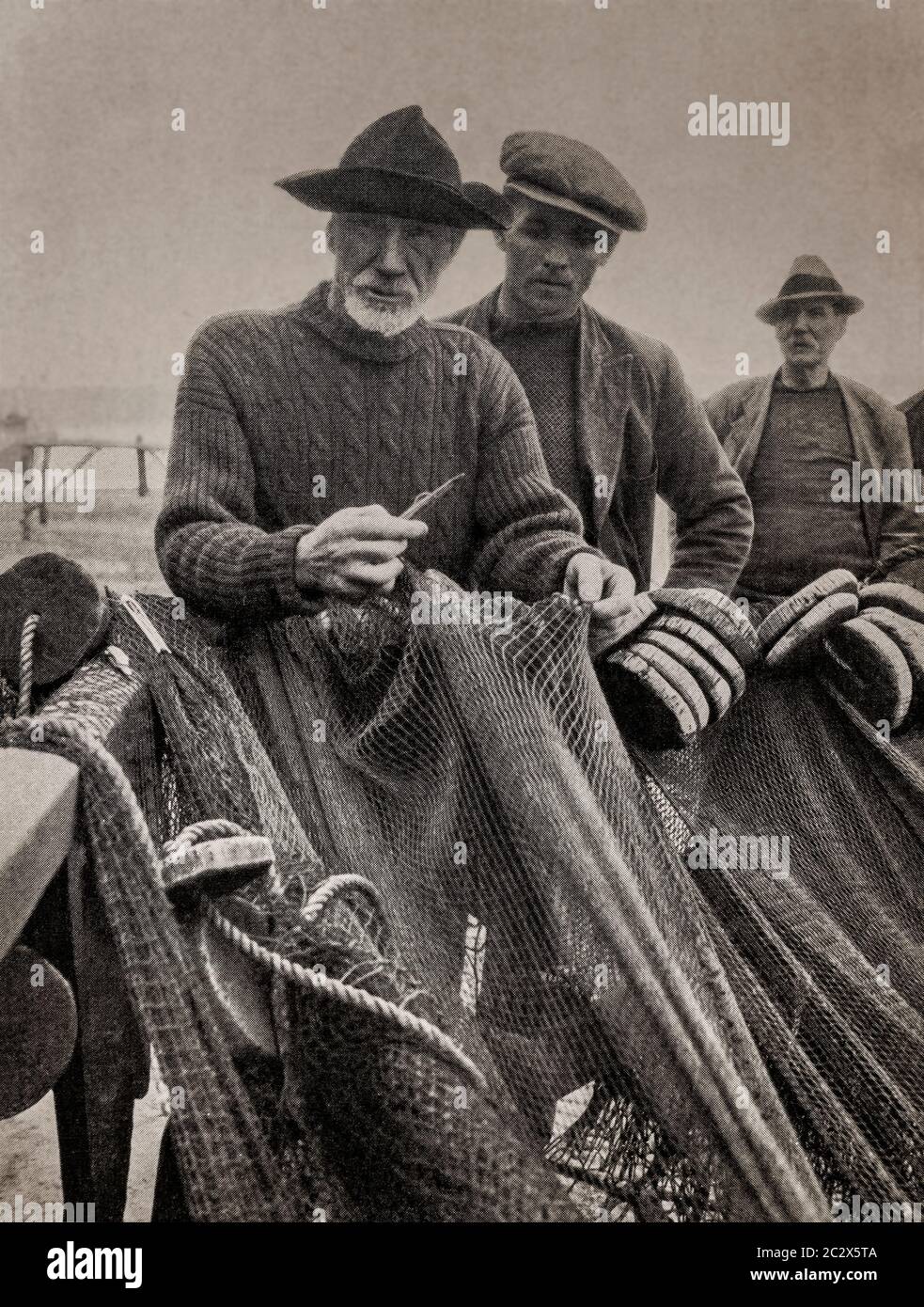 An early 1920's photograph of fishermen repairing nets in Youghal ...