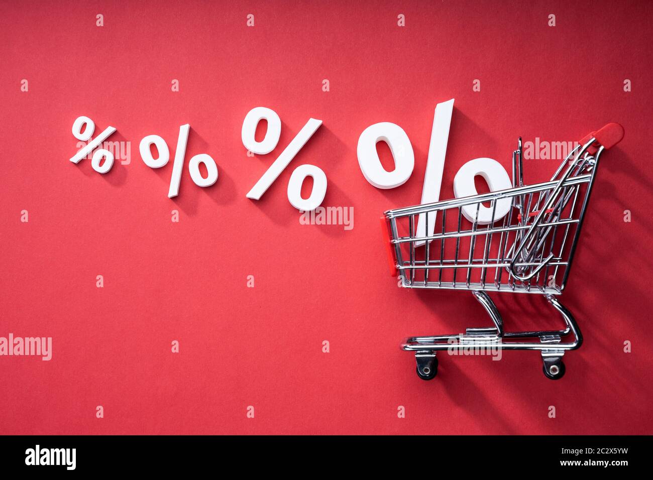 Sale Percents Falling Into Shopping Cart On Red Background Stock Photo ...