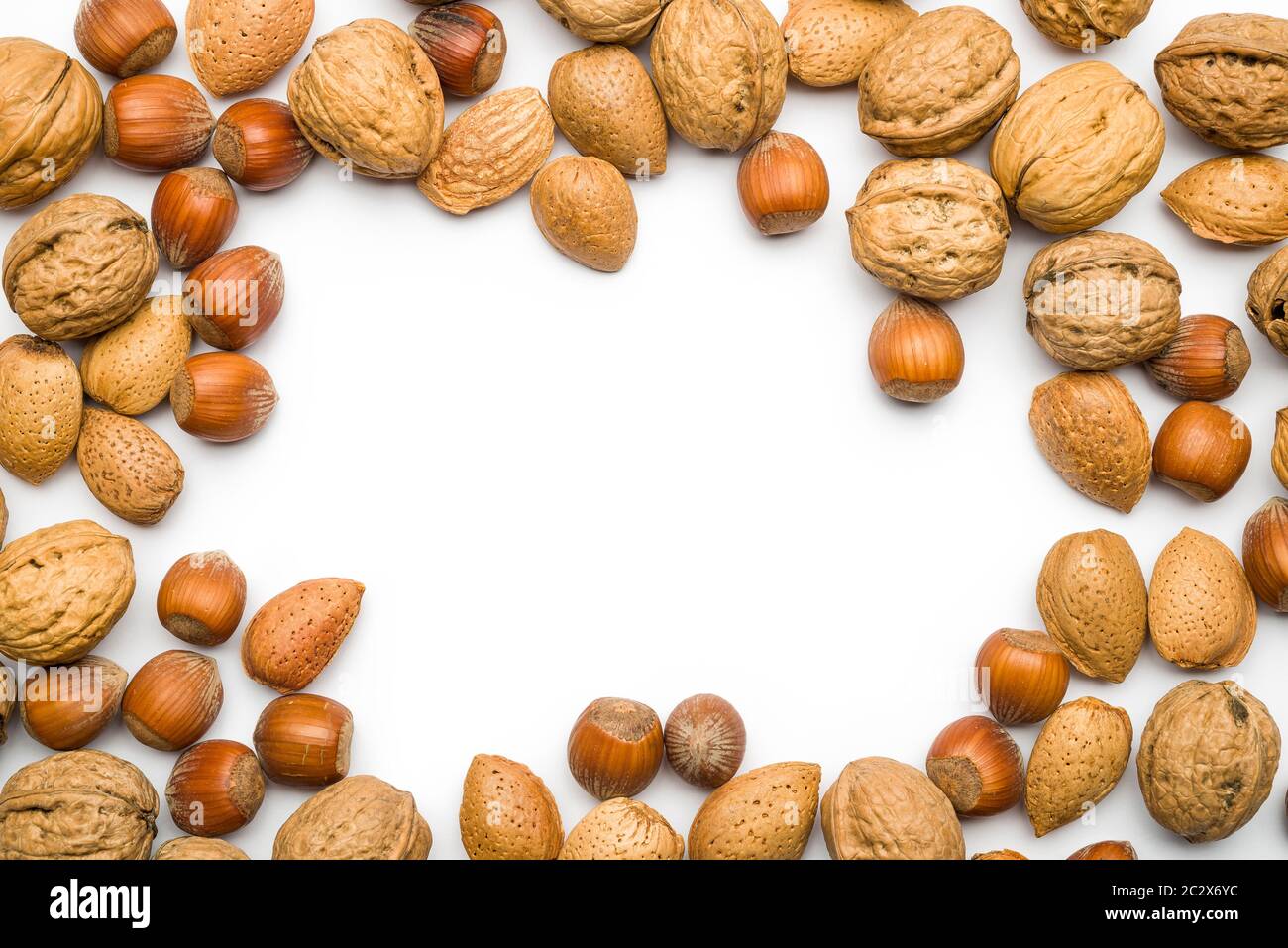 top view of mix of nuts scattered on white background with copy space ...
