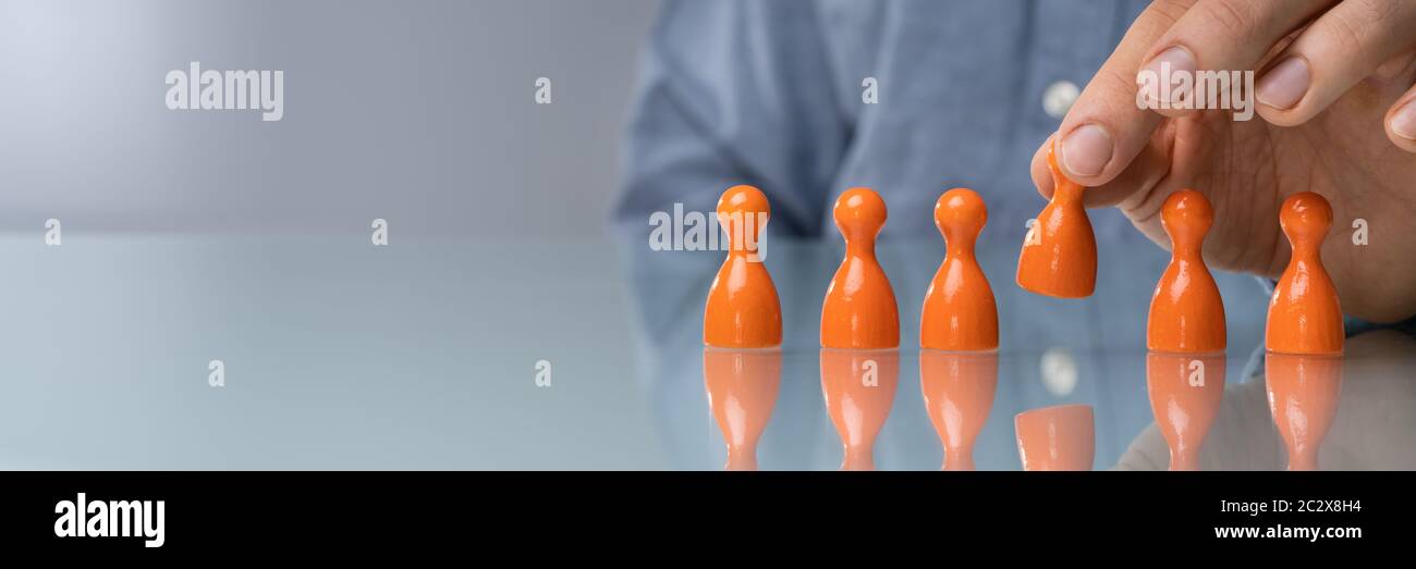 Close-up Of A Person Picking Orange Figure From The Row Over The ...