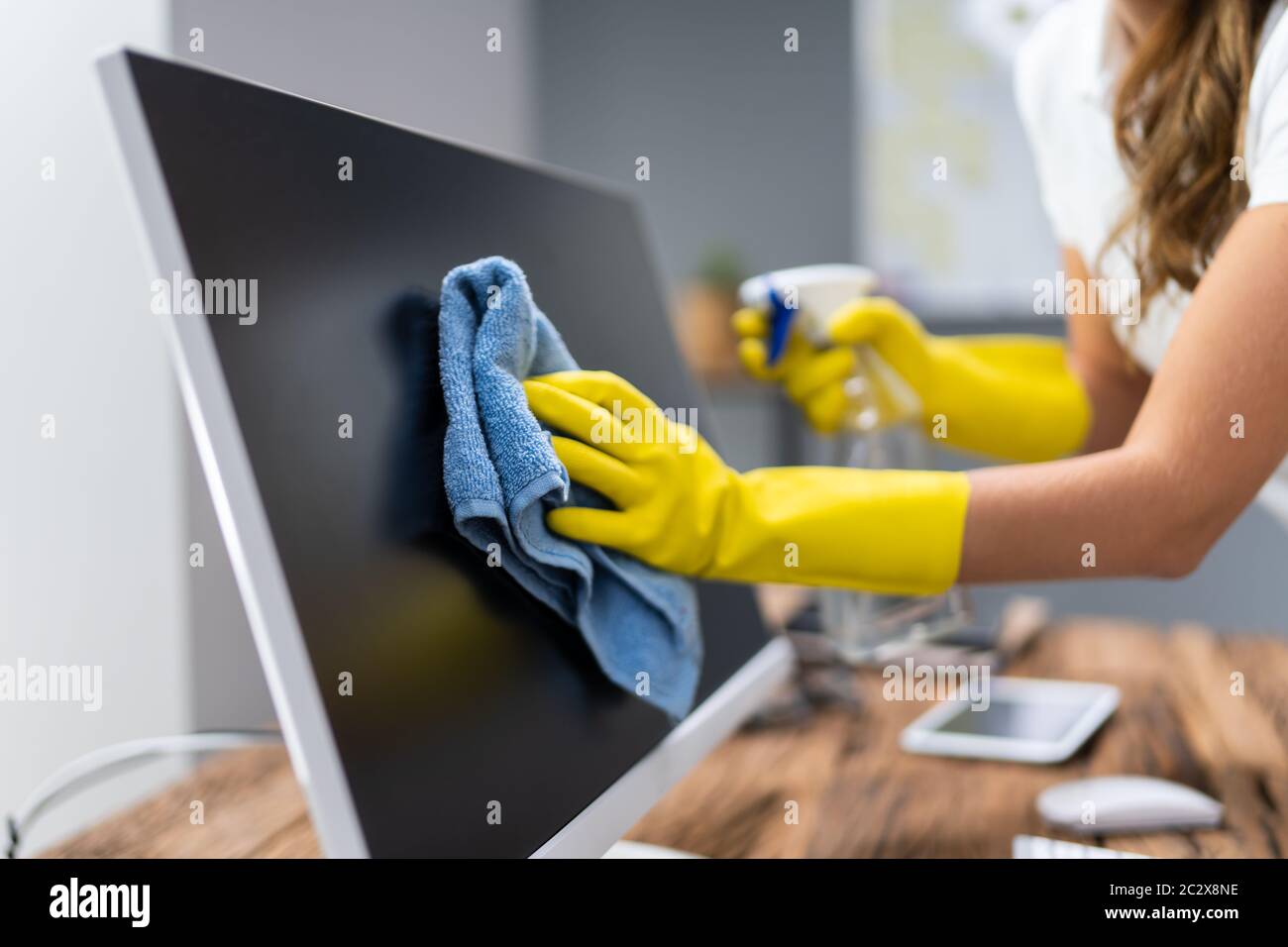 Young Worker Cleaning Desk With Rag In Office Stock Photo - Alamy