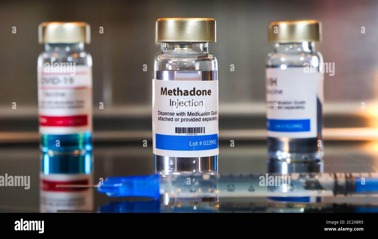 Vial of methadone injection with a syringe on black table and stainless ...