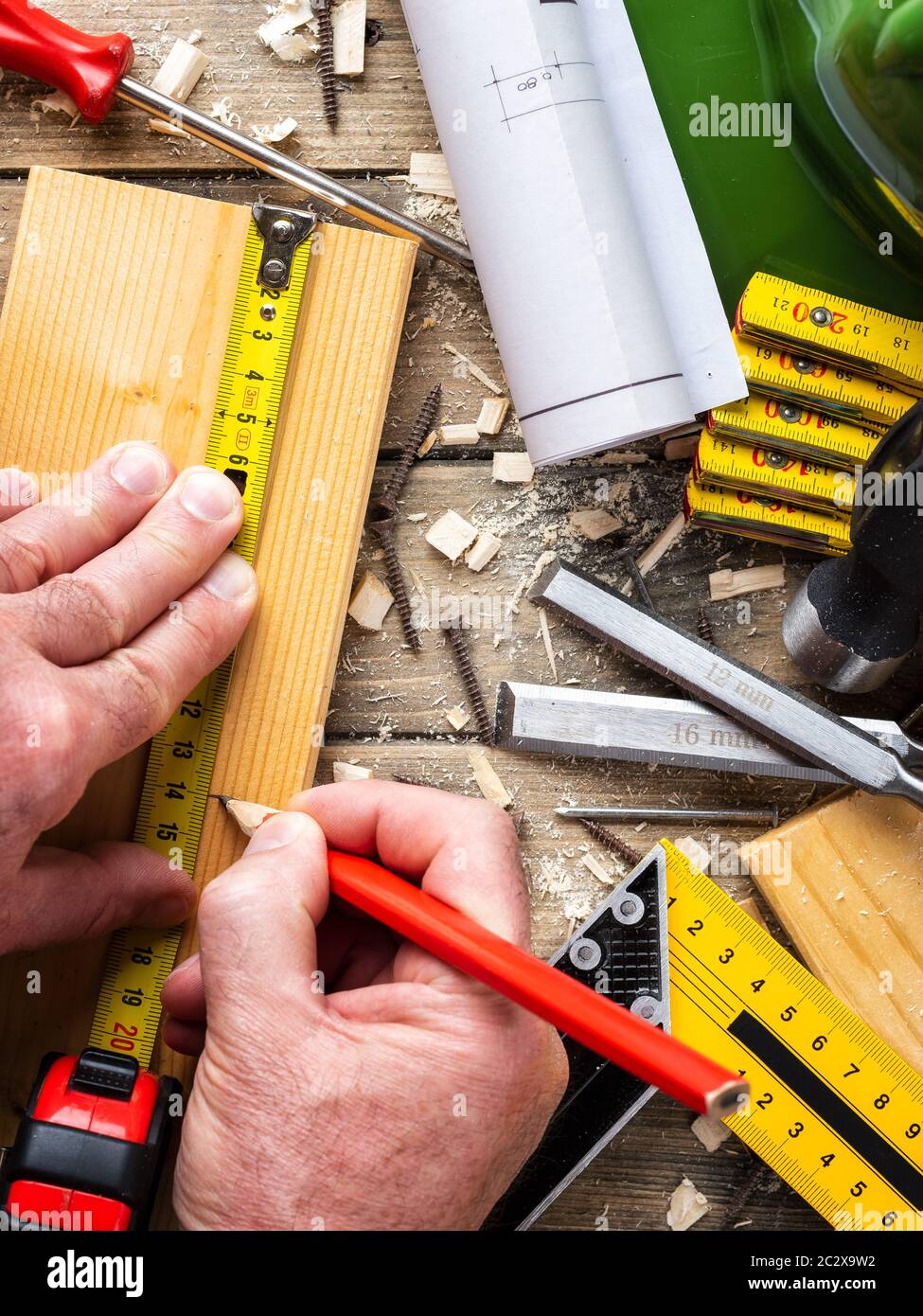 Top view. Carpenter with pencil and the meter marks the measurement on ...