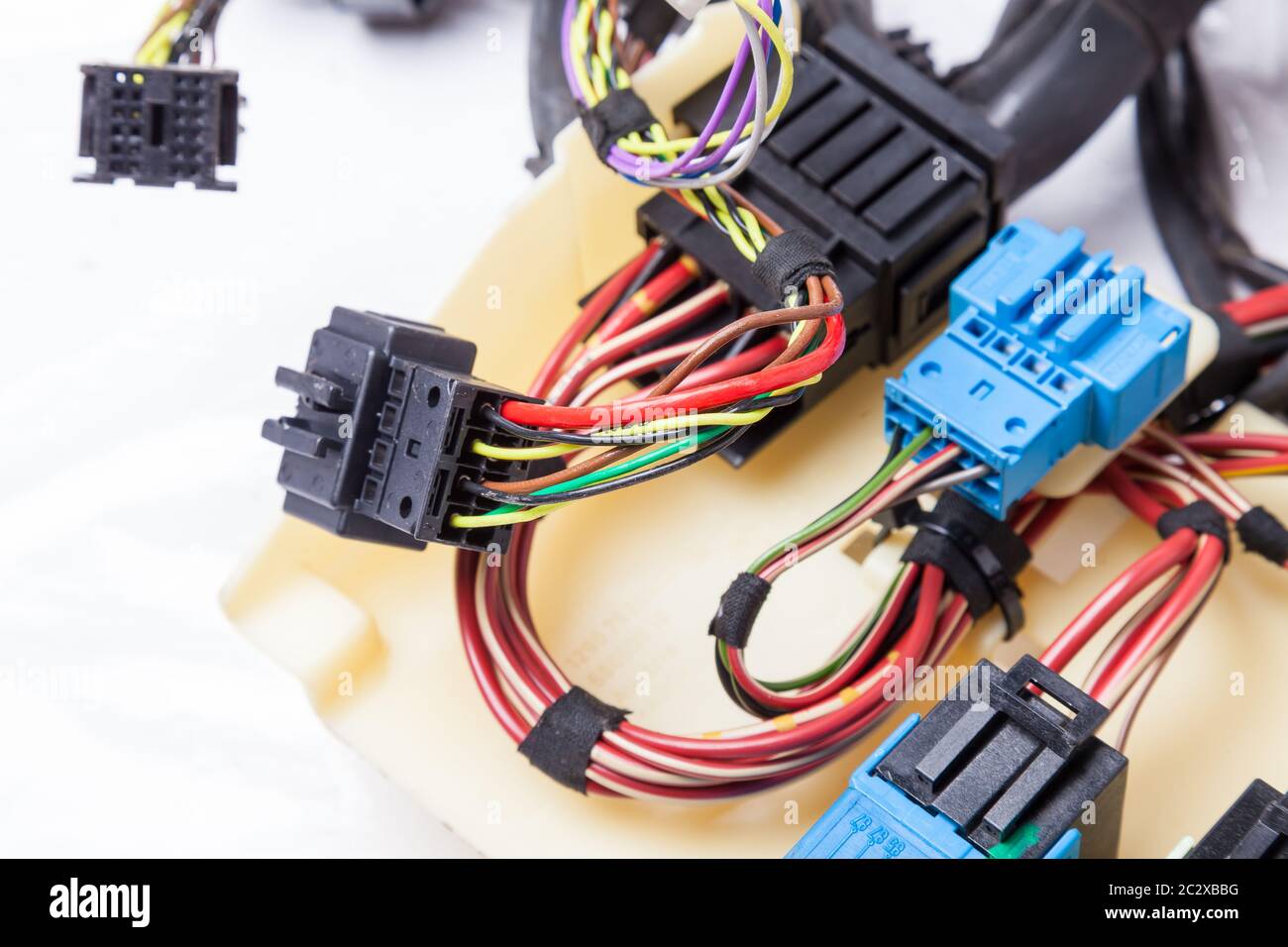 Multi-colored electrical wires with car connectors on a white isolated ...