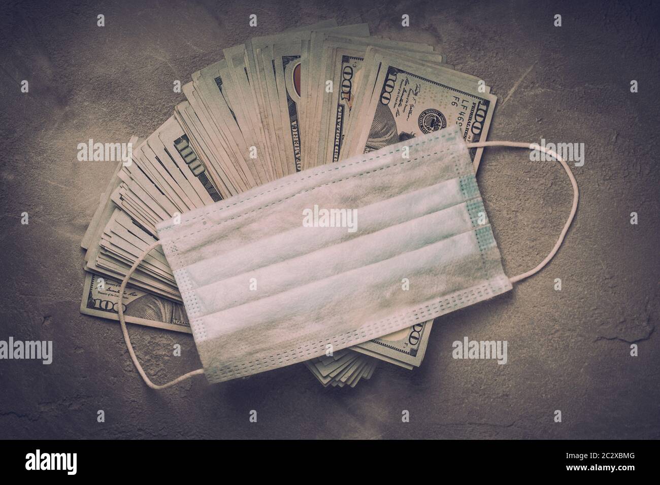 Medical face masks and money. Pneumonia, coronavirus. dramatic light ...