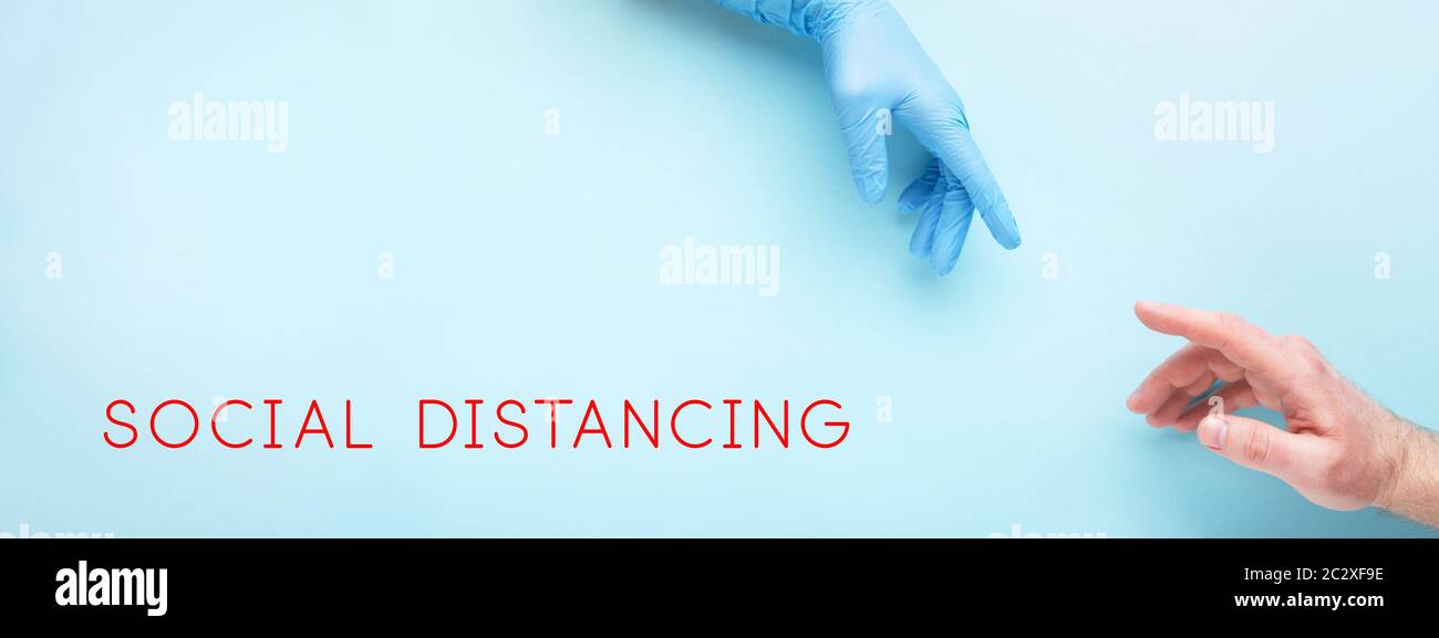 Social distancing concept with female's hand in glove and man's hand on ...