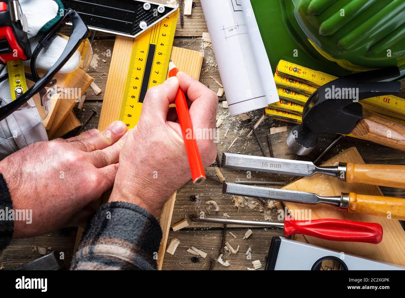 Top view. Carpenter with pencil and the carpenter's square draw the ...