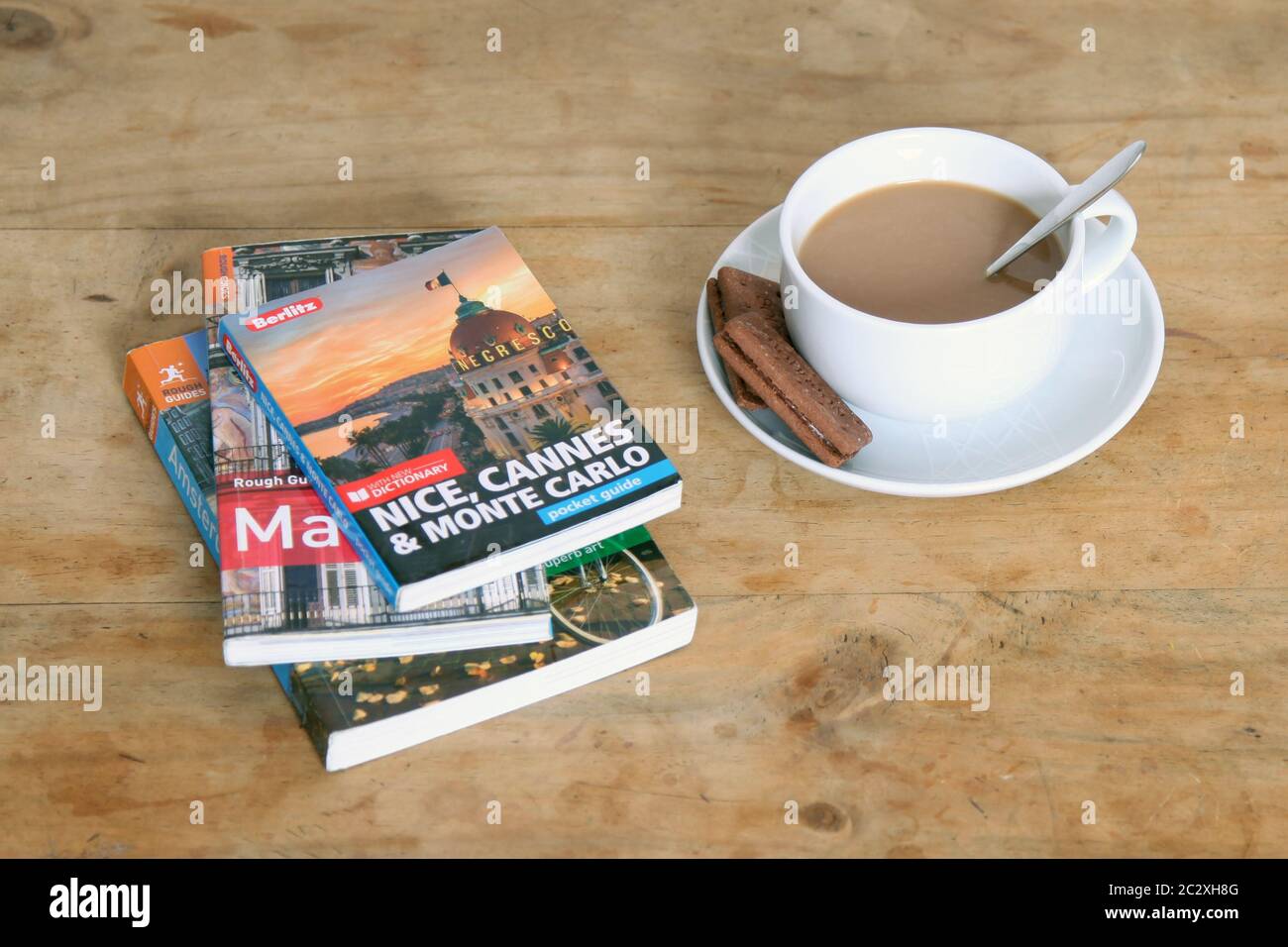 Travel books with cup of tea in white teacup on wooden table Stock ...