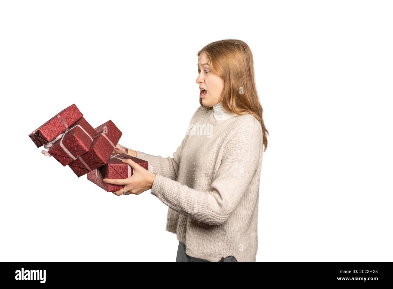 A young woman drops down a stack of presents while walking Stock Photo ...