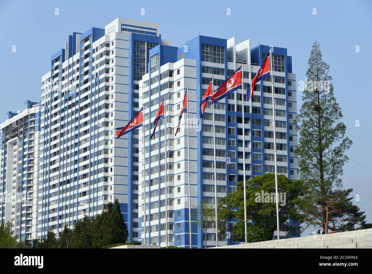Residential district in the city Pyongyang, North Korea. National flags ...