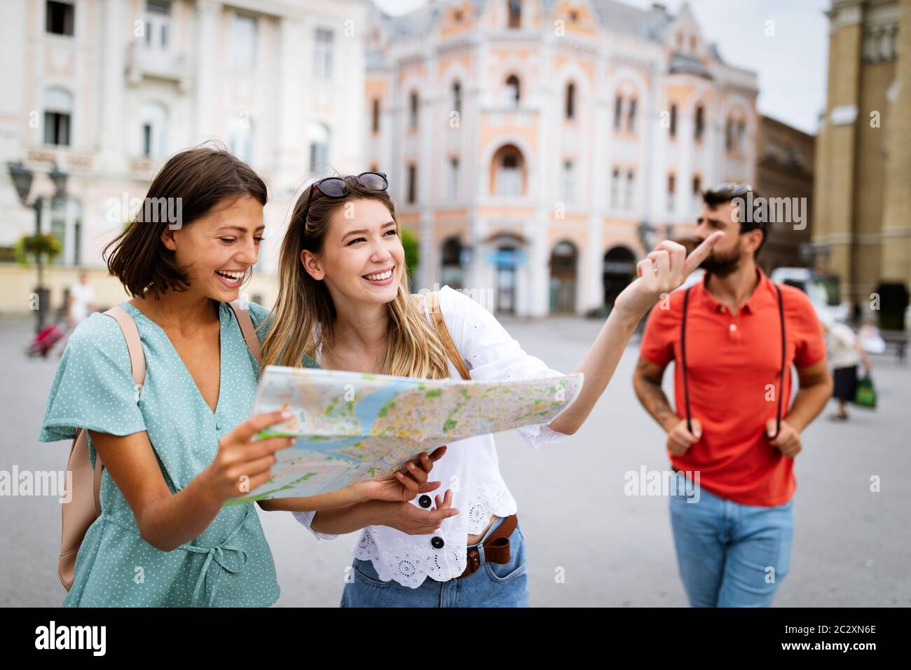 Happy traveling tourists sightseeing with map in hand Stock Photo - Alamy