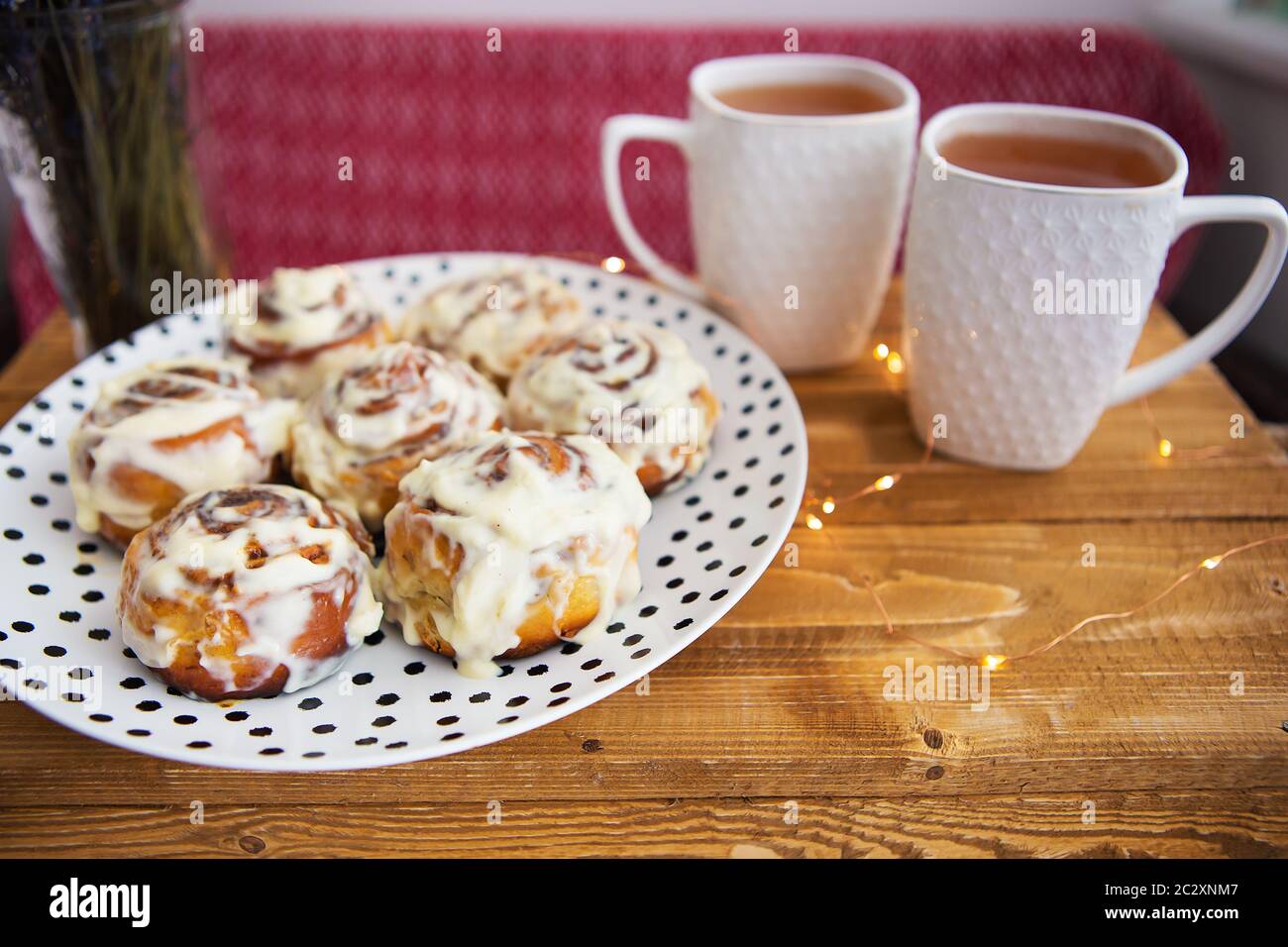 Two cups of black tea stand on a wooden tray, a bouquet of dried ...