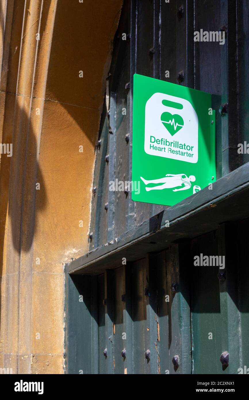 A defibrillator sign on a church door in a village in Hertfordshire ...