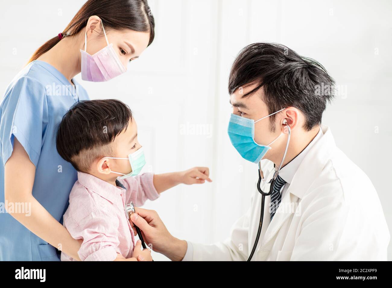 medical doctor examining little boy in clinic Stock Photo - Alamy