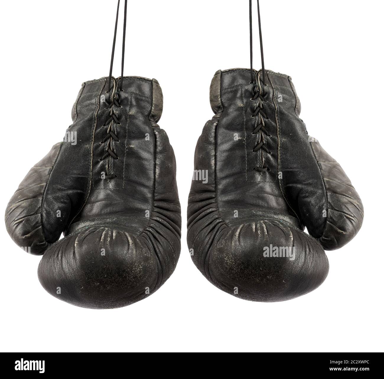 pair of very old vintage black leather boxing gloves hanging on a rope ...