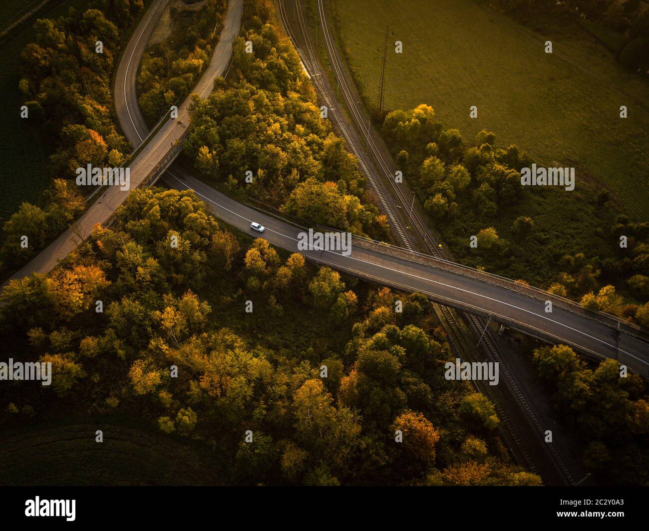 Winding road in autumn forest at sunset in mountains. Aerial view. Top ...