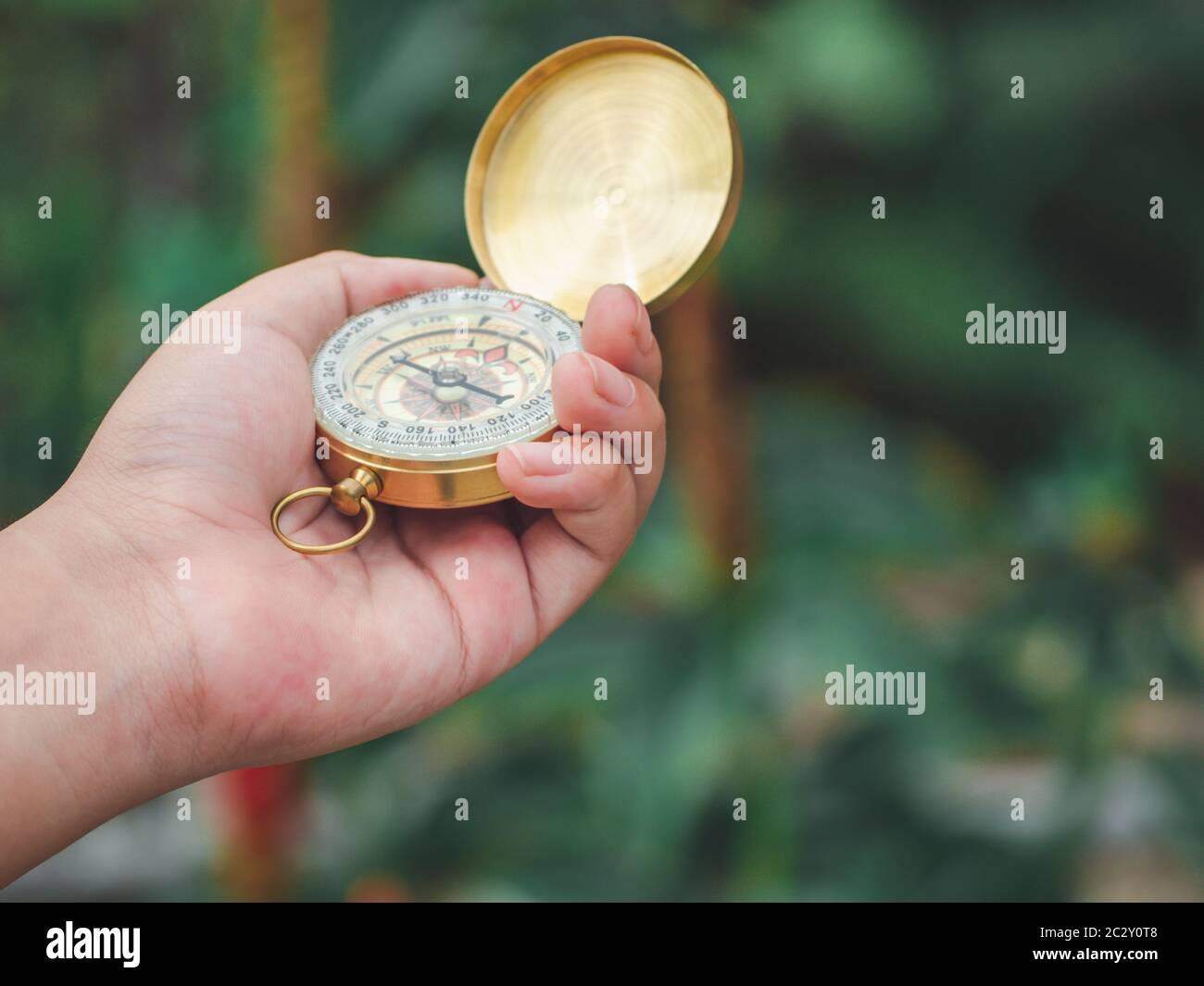 Hand of child hand using magnetic golden compass while traveling in the ...