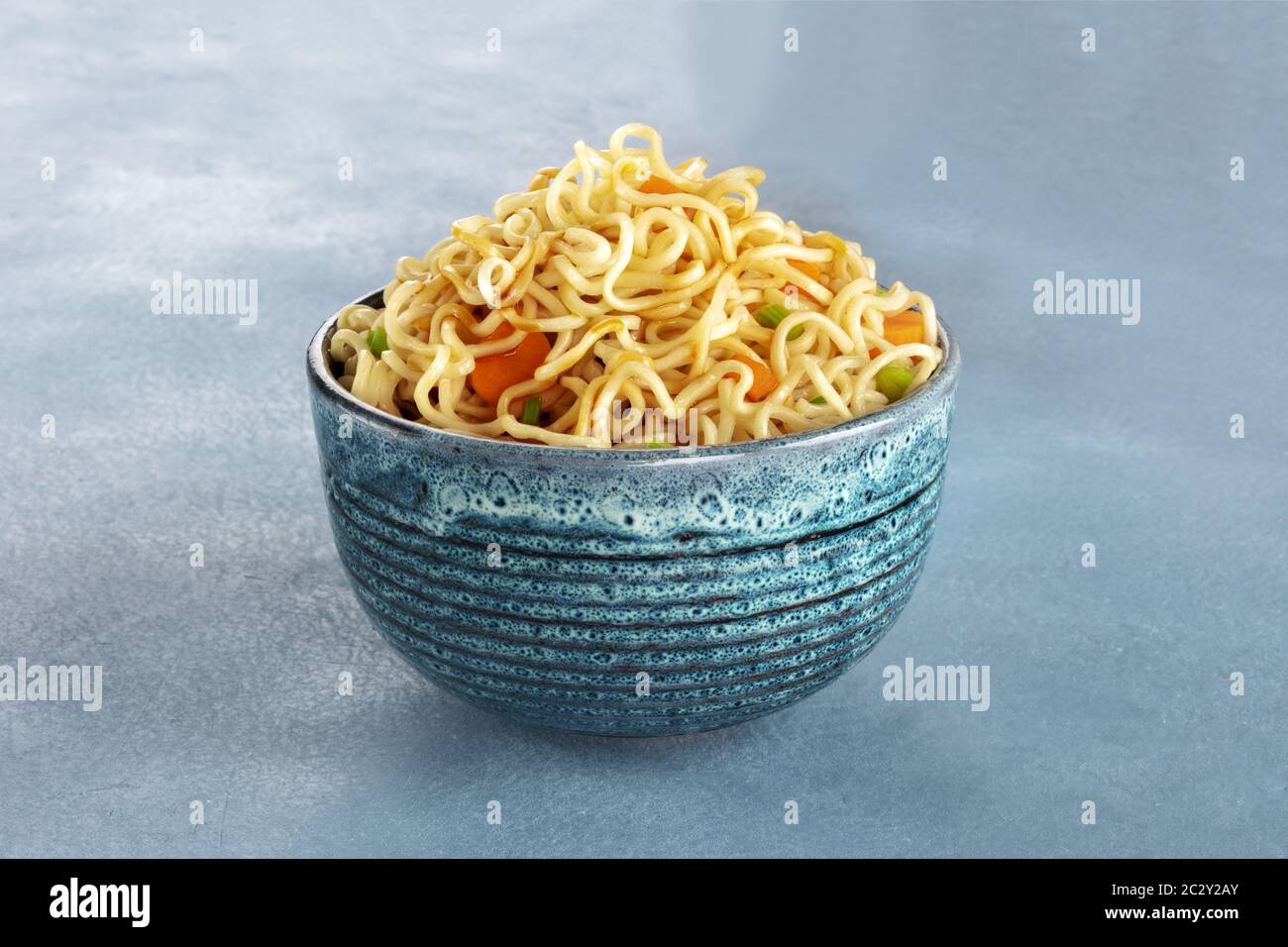 Instant noodles with carrot, scallions, and sauce, on a slate ...