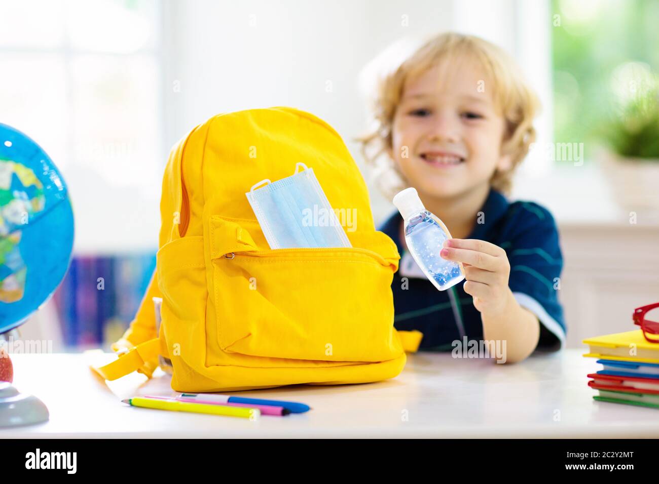 School child with backpack, face mask and sanitizer. Student safety ...