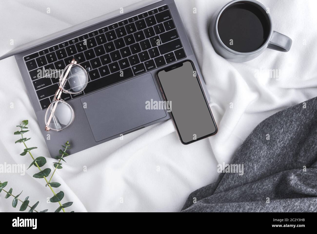Electronics layout in a white and gray bed flat lay Stock Photo - Alamy