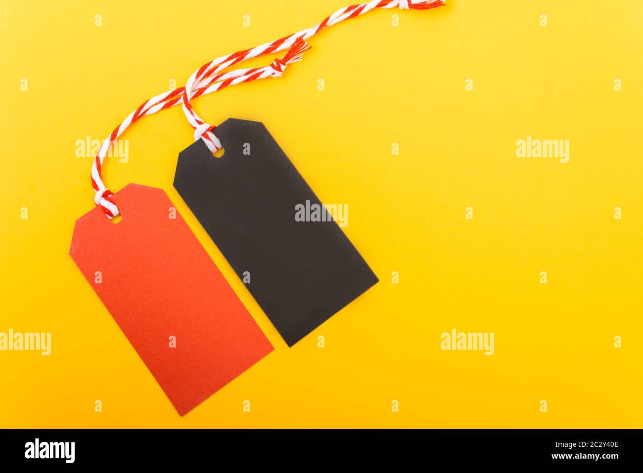 Red tag label and Black tag label on yellow background, blank copy ...