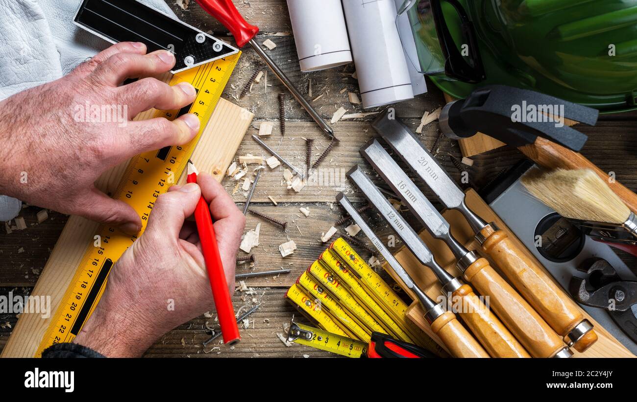 Top view. Carpenter with pencil and the carpenter's square draw the ...