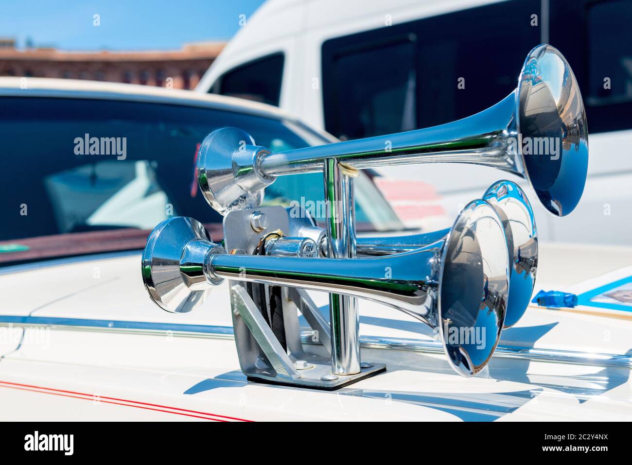A close-up view of a chrome horn on the hood of a car Stock Photo - Alamy