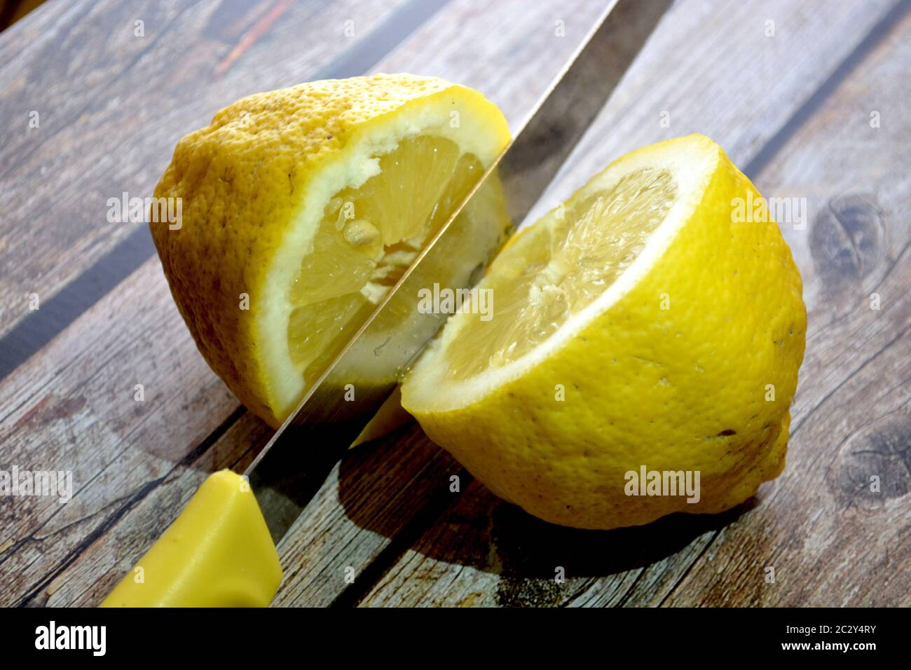 lemon cut in half with knife Stock Photo - Alamy