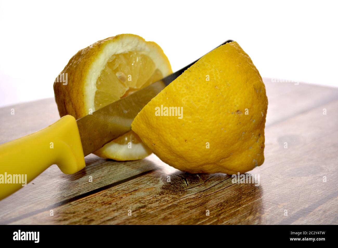 lemon cut in half with knife Stock Photo - Alamy