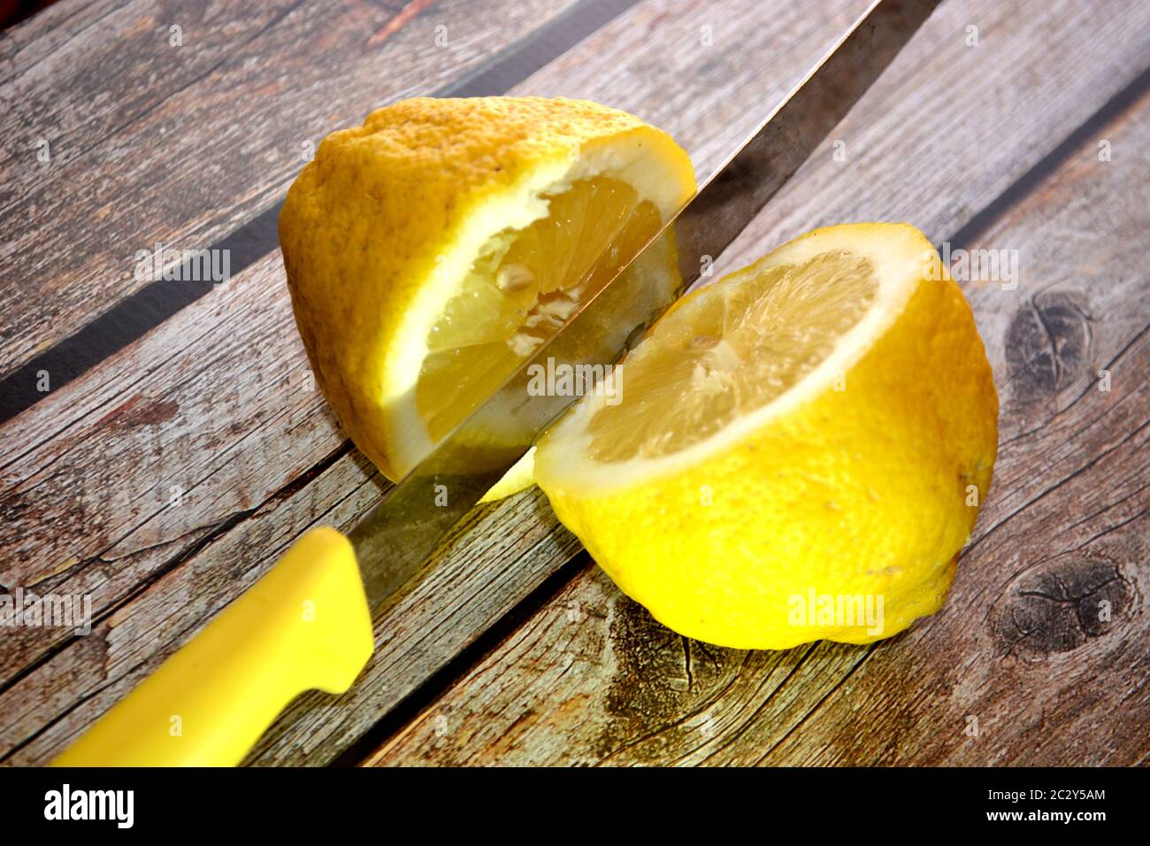 lemon cut in half with knife Stock Photo - Alamy